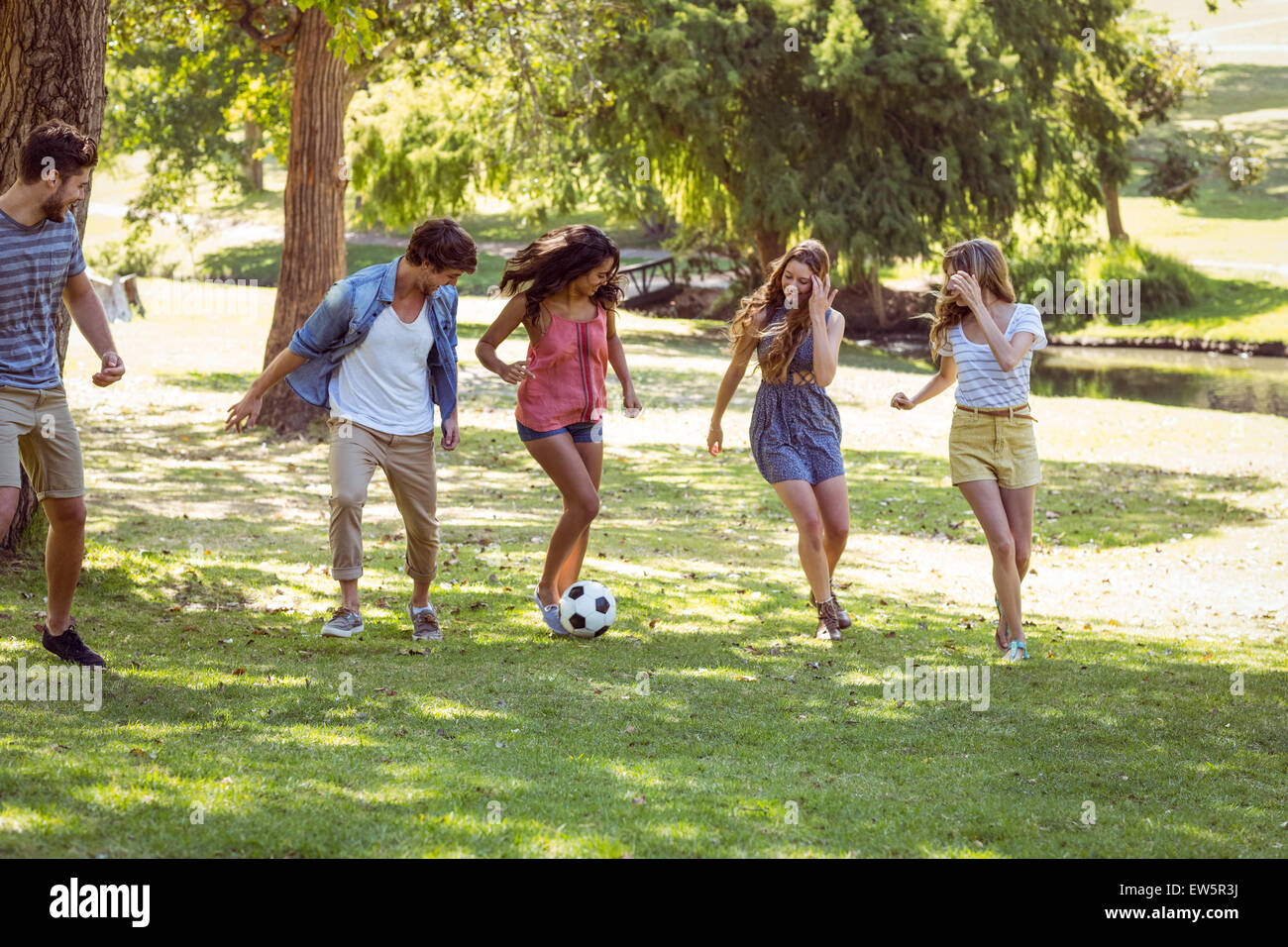 Happy friends in the park with football Stock Photo - Alamy
