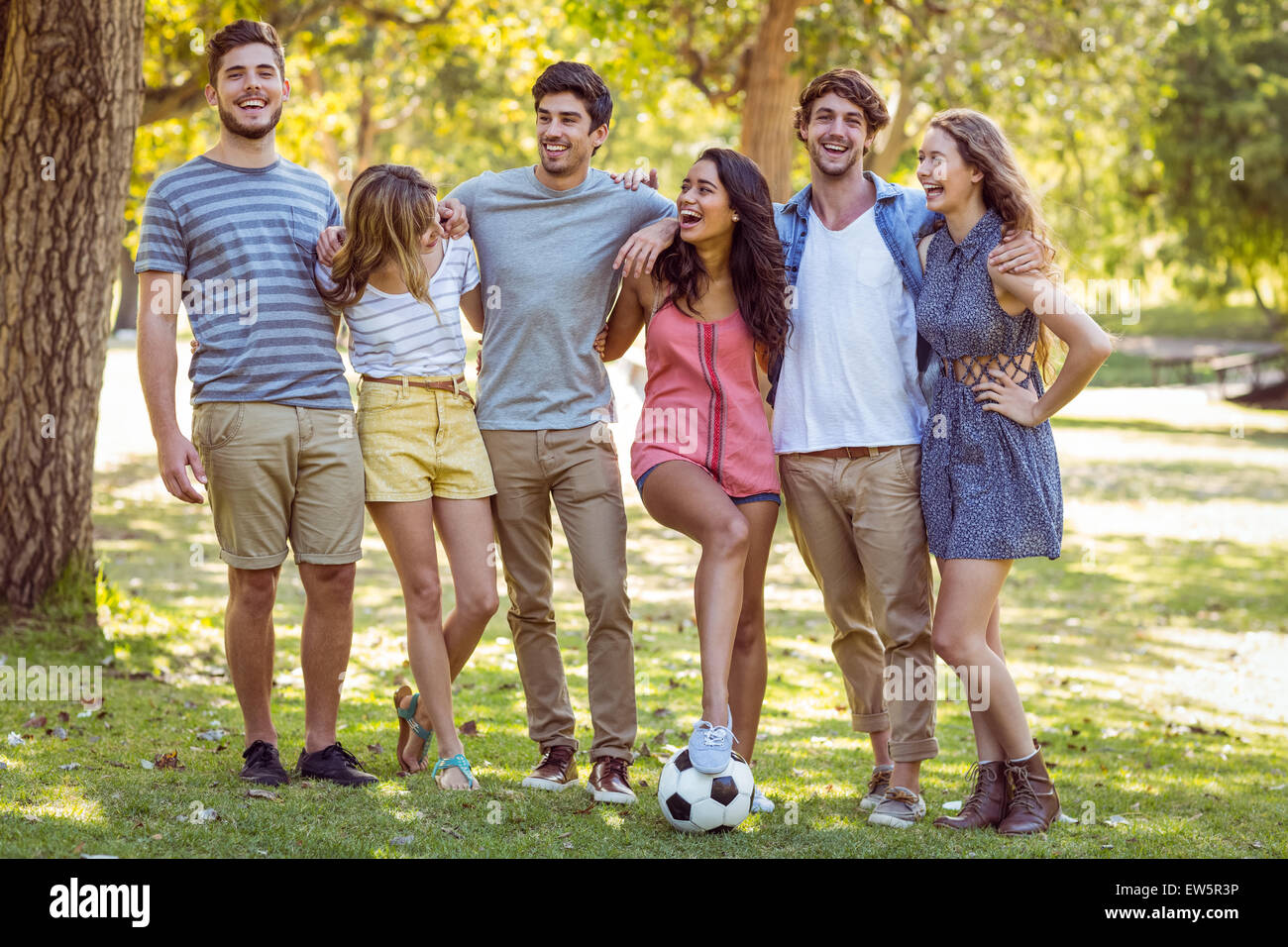 Happy friends in the park with football Stock Photo - Alamy