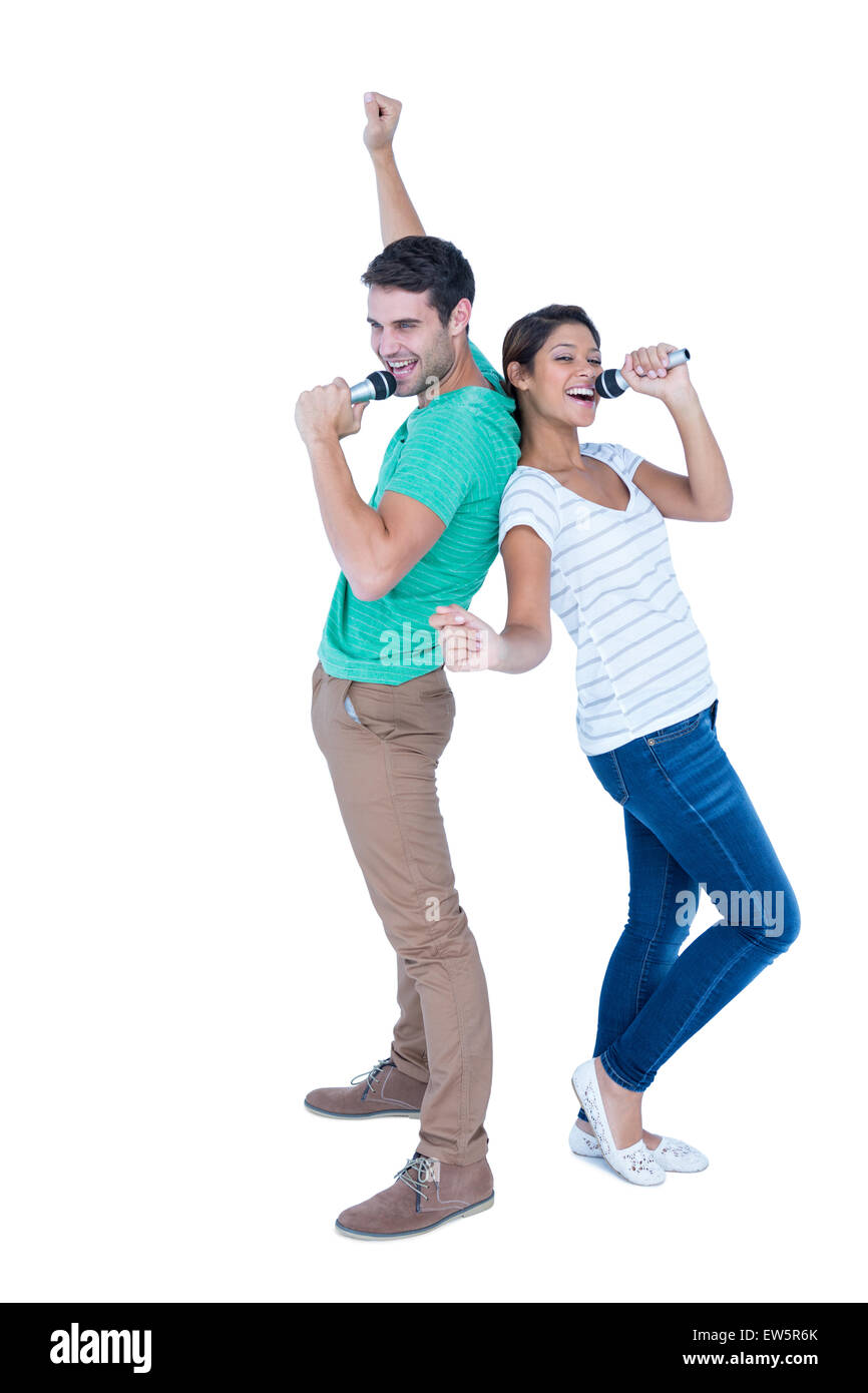 Friends singing in a microphone back to back Stock Photo - Alamy