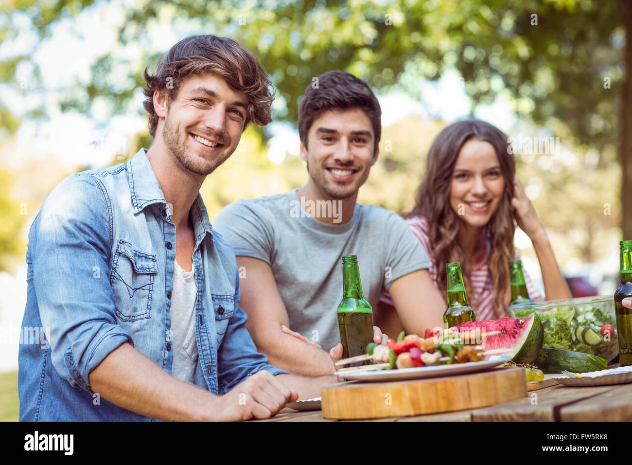 Happy friends in the park having lunch Stock Photo - Alamy
