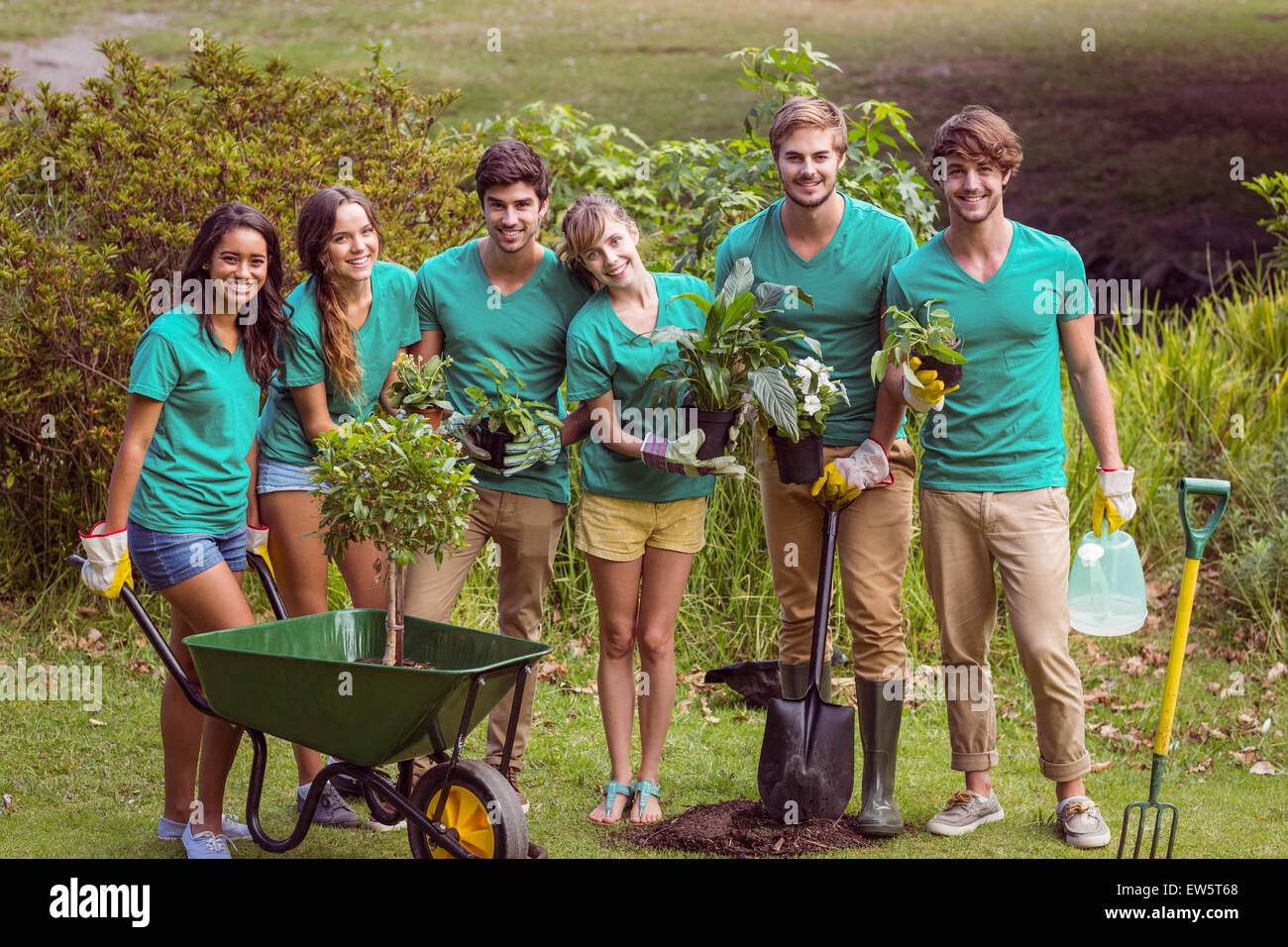 Happy friends gardening for the community Stock Photo - Alamy
