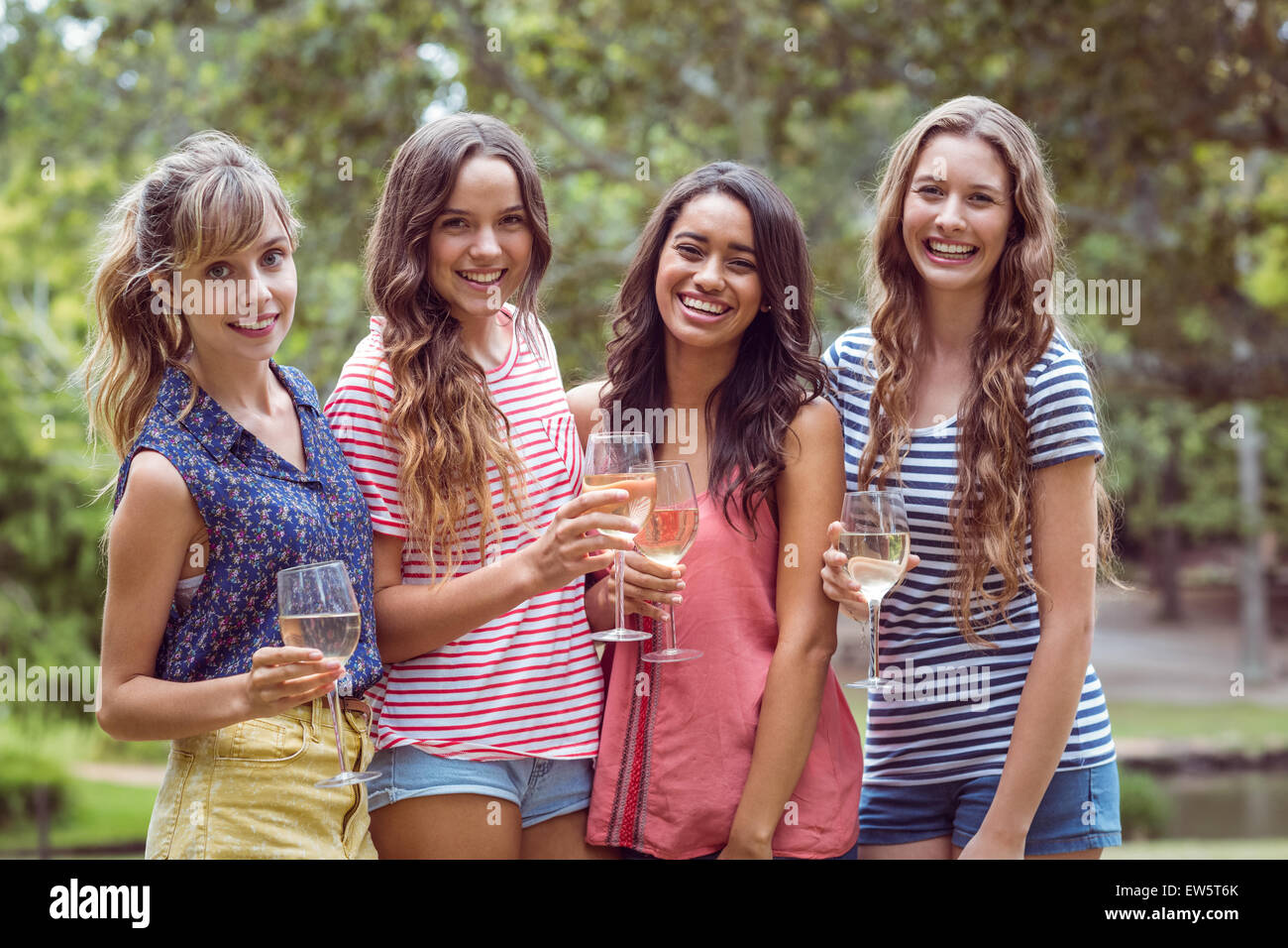 Happy friends drinking in the park Stock Photo - Alamy