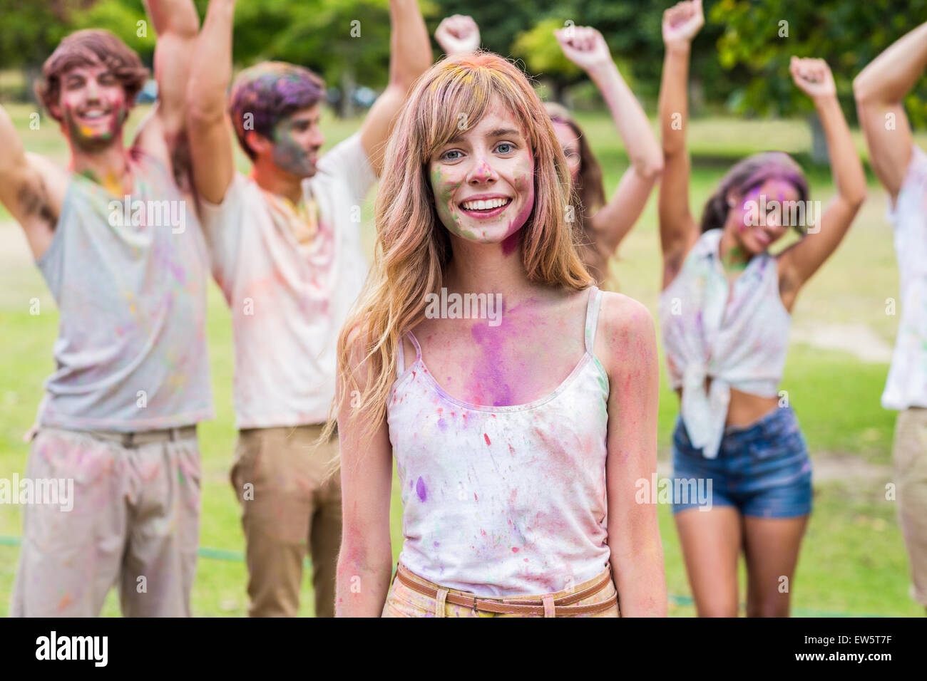 Happy friends throwing powder paint Stock Photo - Alamy