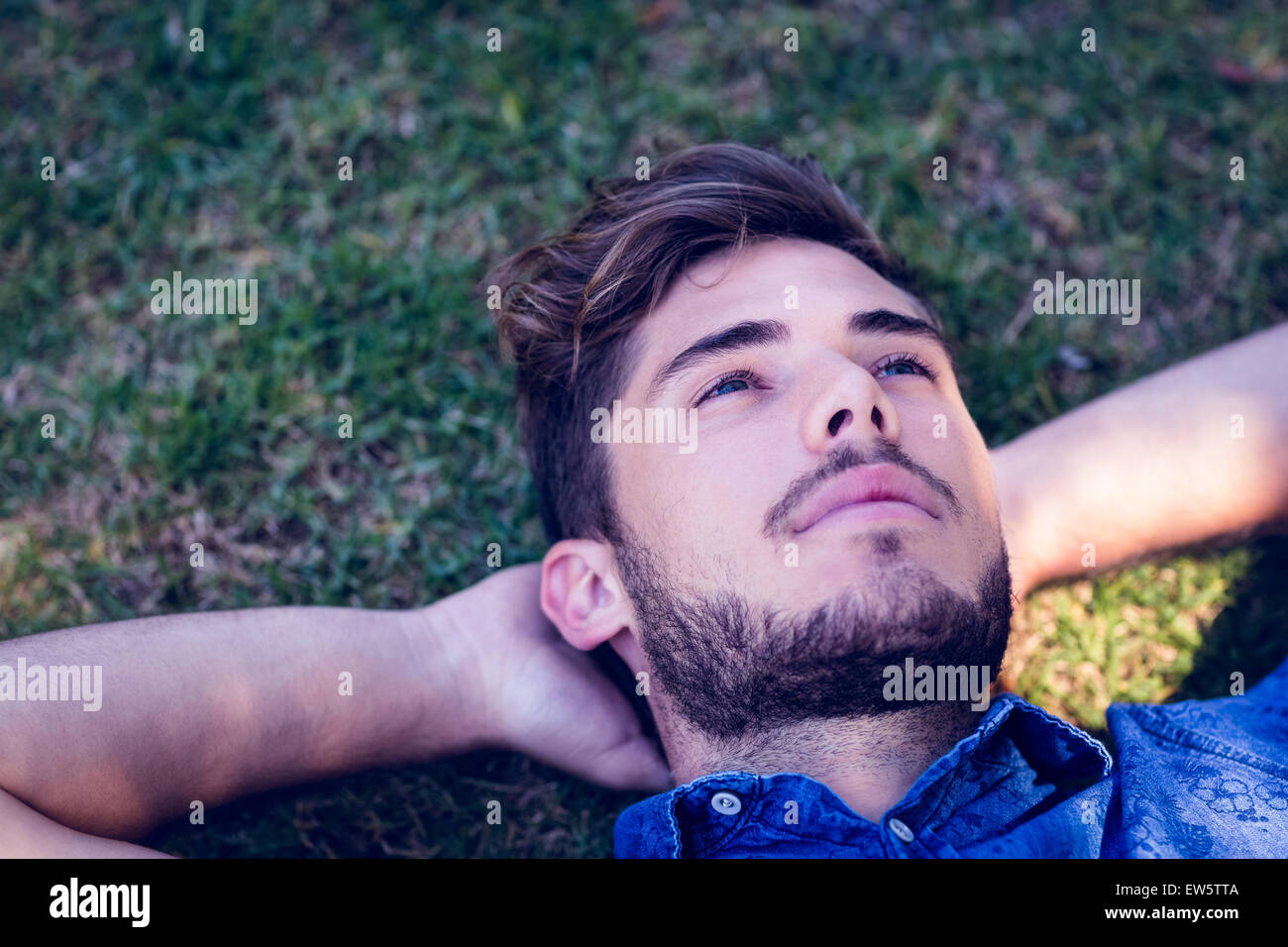 Young man lying down in the park Stock Photo - Alamy