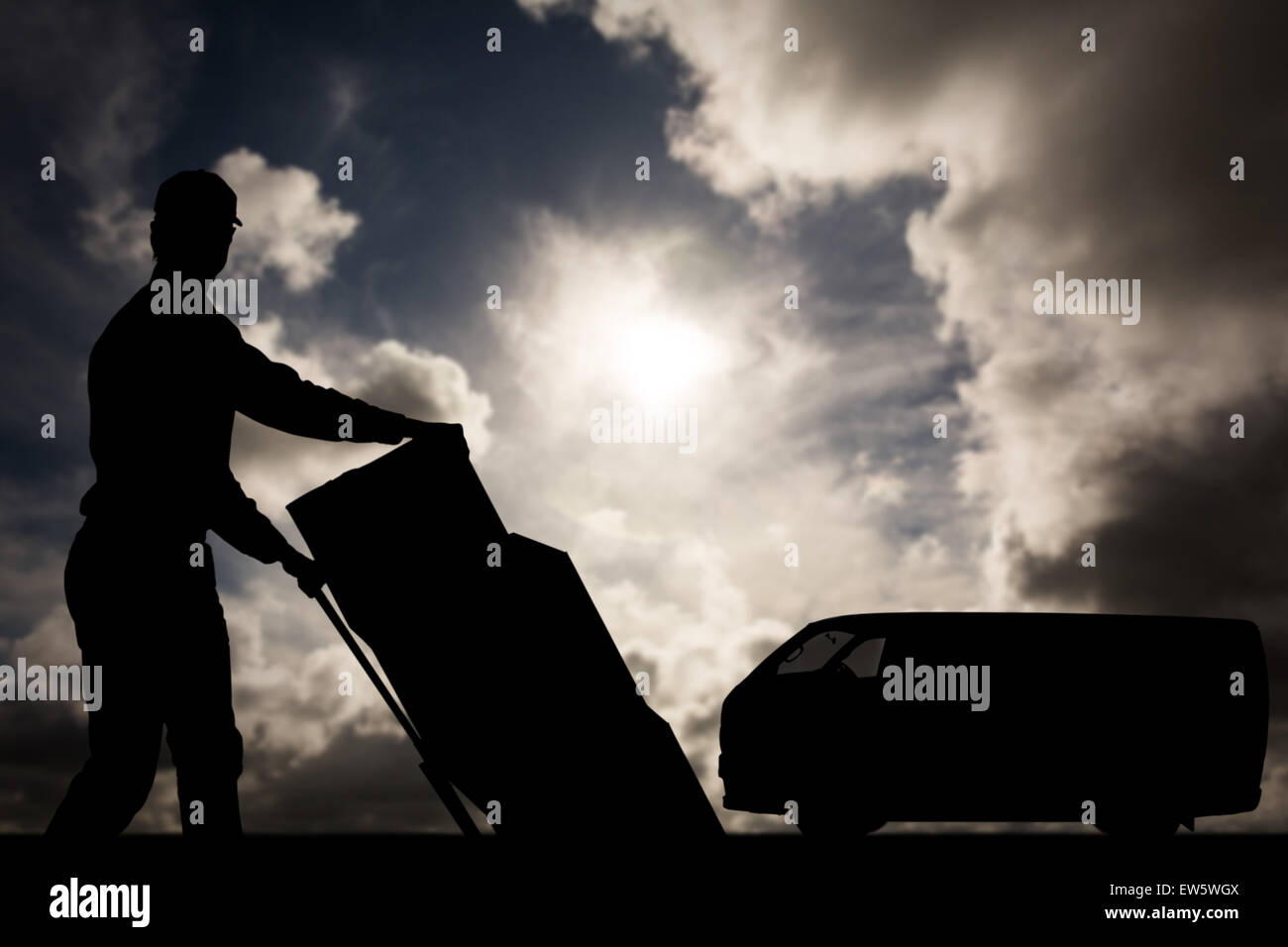 Composite image of happy delivery man pushing trolley of cardboard ...