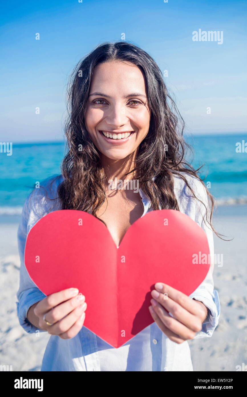 Smiling woman holding heart card at the beach Stock Photo - Alamy Smiling woman holding heart card at the beach Stock Photo - Alamy