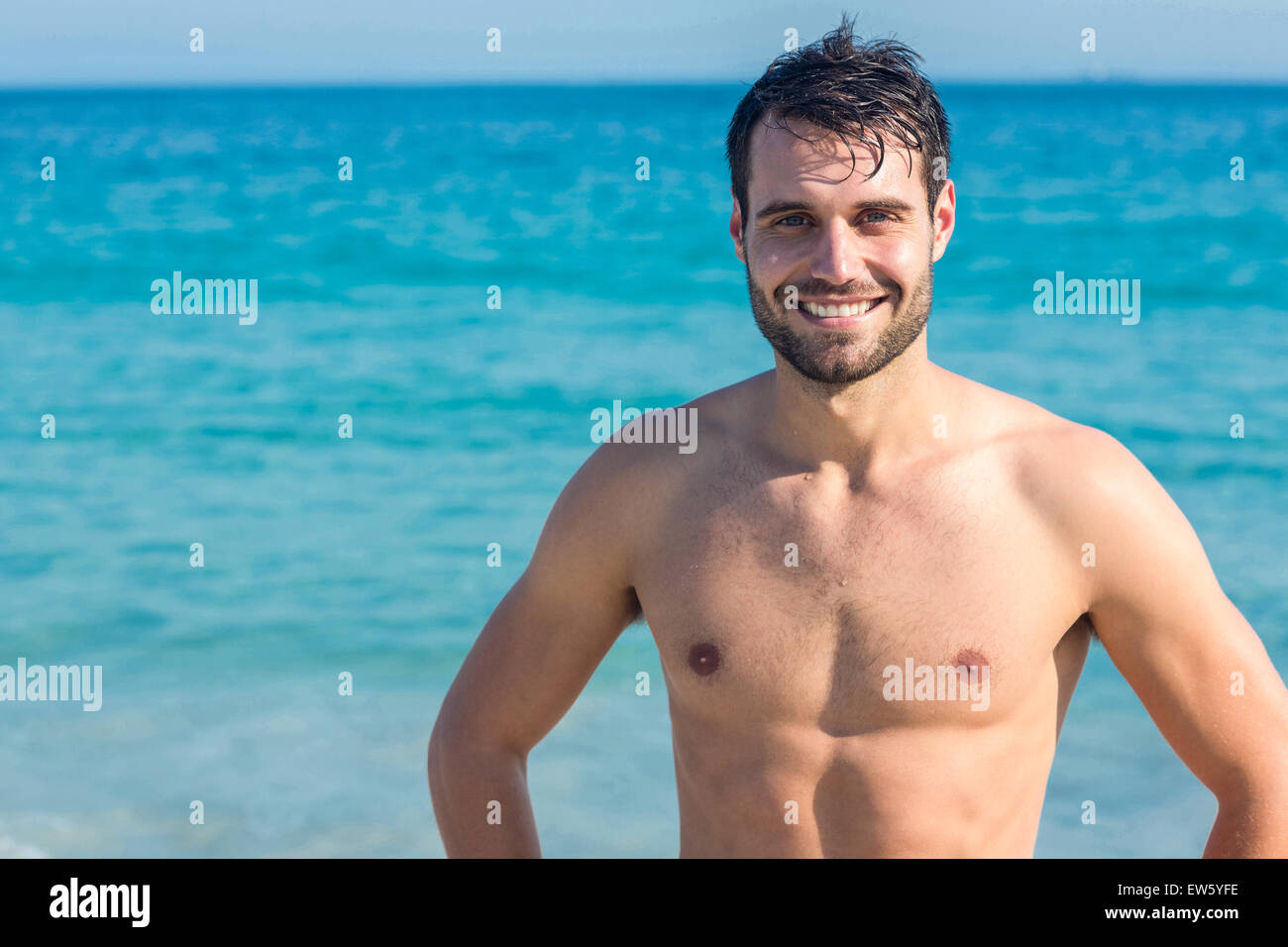 Smiling man at the beach looking at camera Stock Photo - Alamy