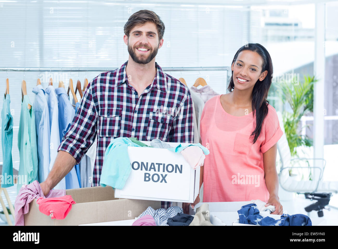 Smiling young friends volunteers separating clothes Stock Photo - Alamy
