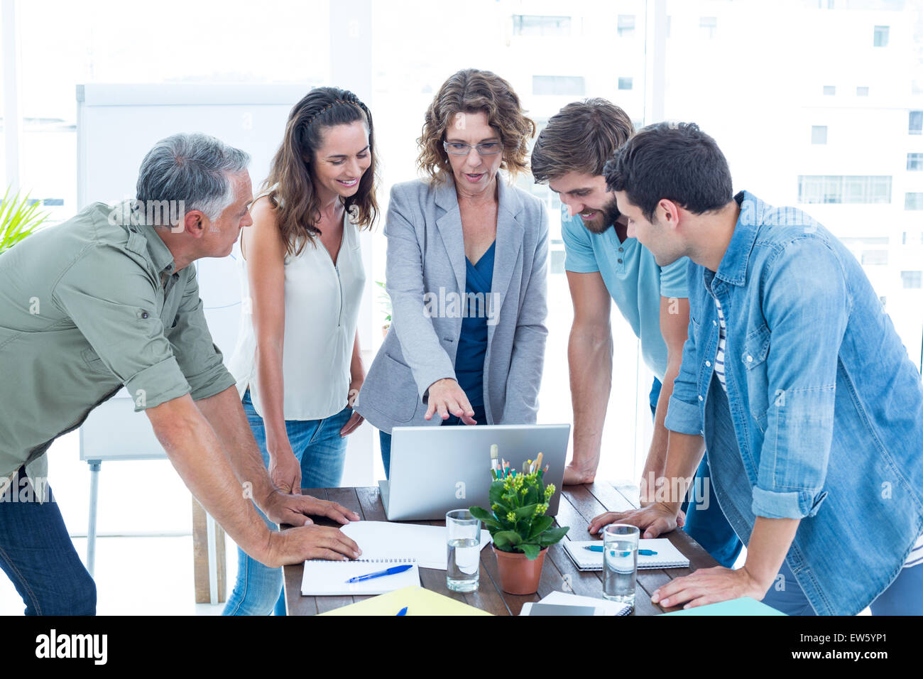 Casual colleagues using laptop in the office Stock Photo - Alamy