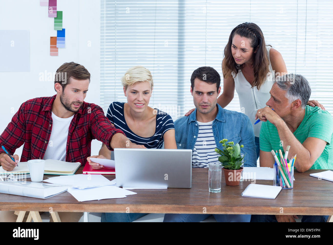 Creative business team using laptop in meeting Stock Photo - Alamy