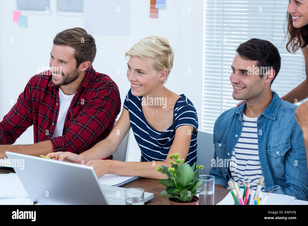 Creative business team using laptop in meeting Stock Photo - Alamy