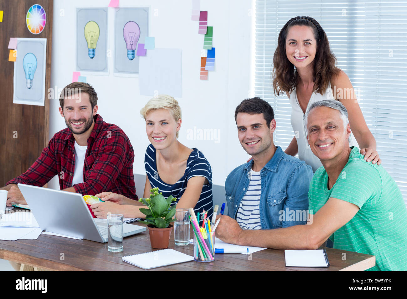 Creative business team using laptop in meeting Stock Photo - Alamy