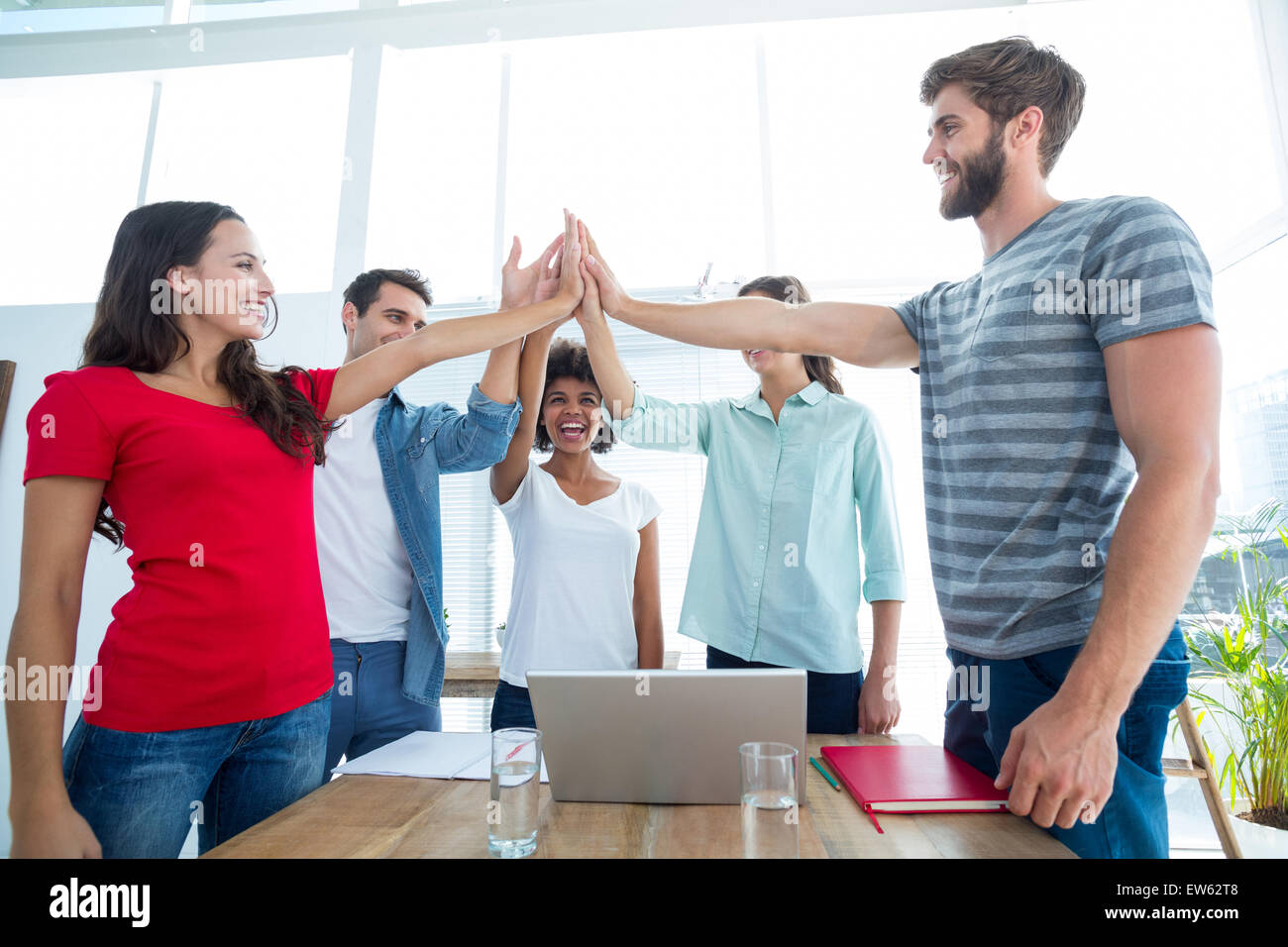 Happy business team putting their hands together Stock Photo - Alamy