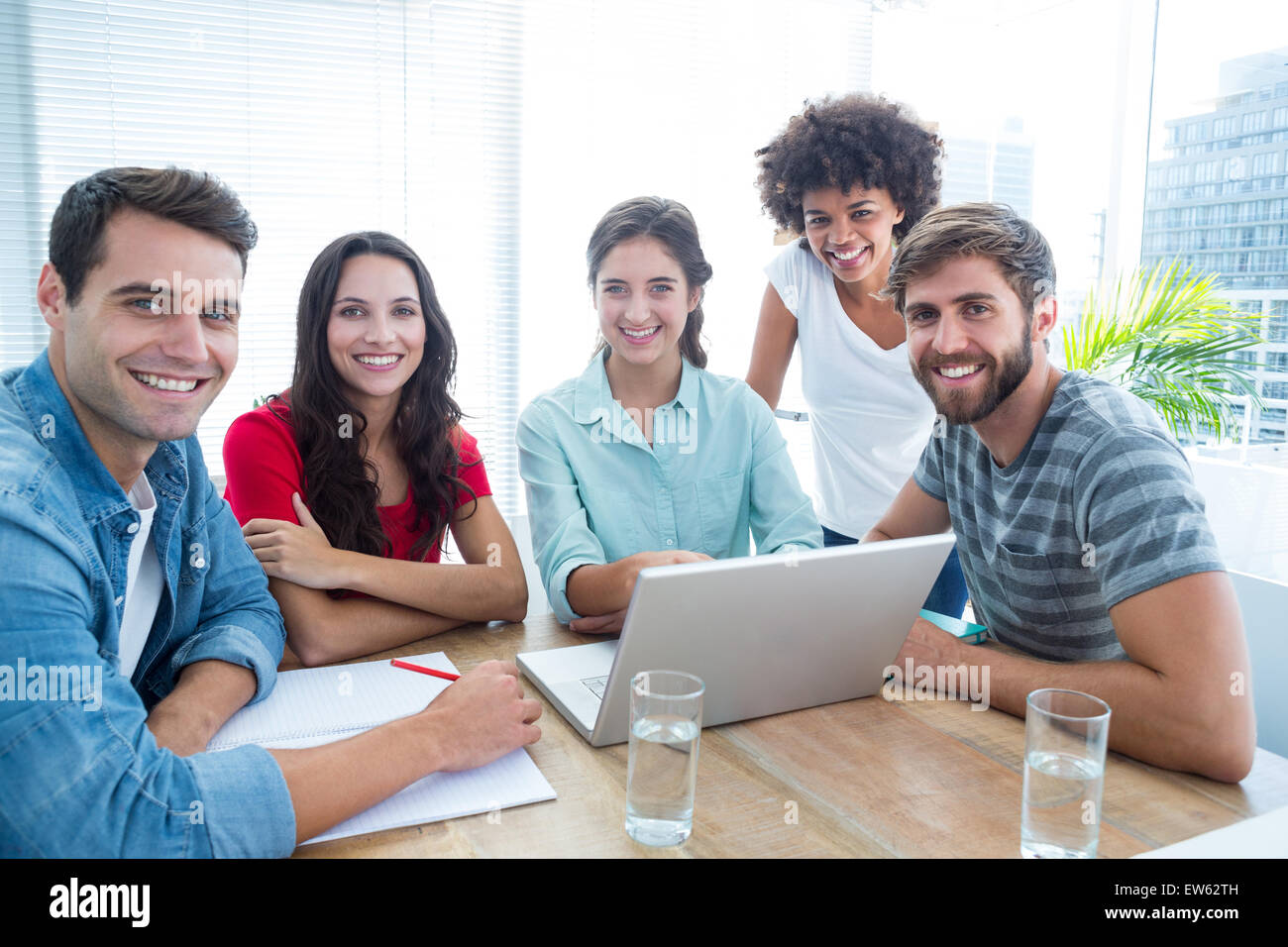Colleagues using laptop at office Stock Photo - Alamy