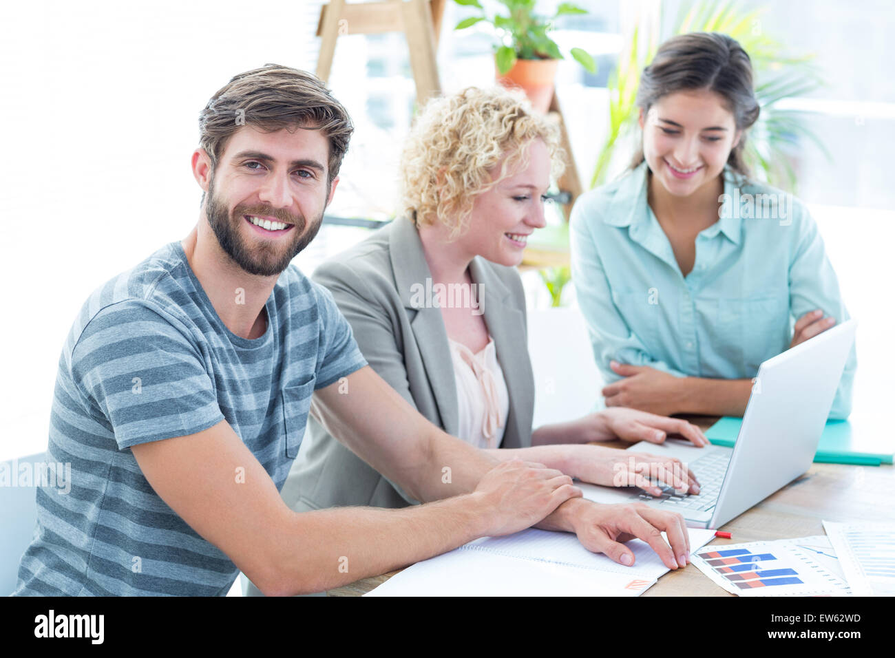 Colleagues using laptop at office Stock Photo - Alamy