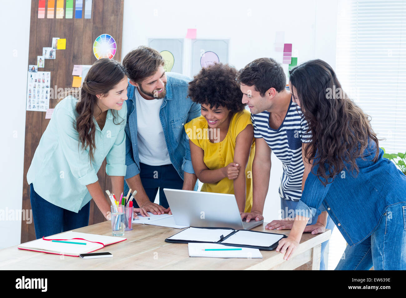 Group of young colleagues using laptop Stock Photo - Alamy