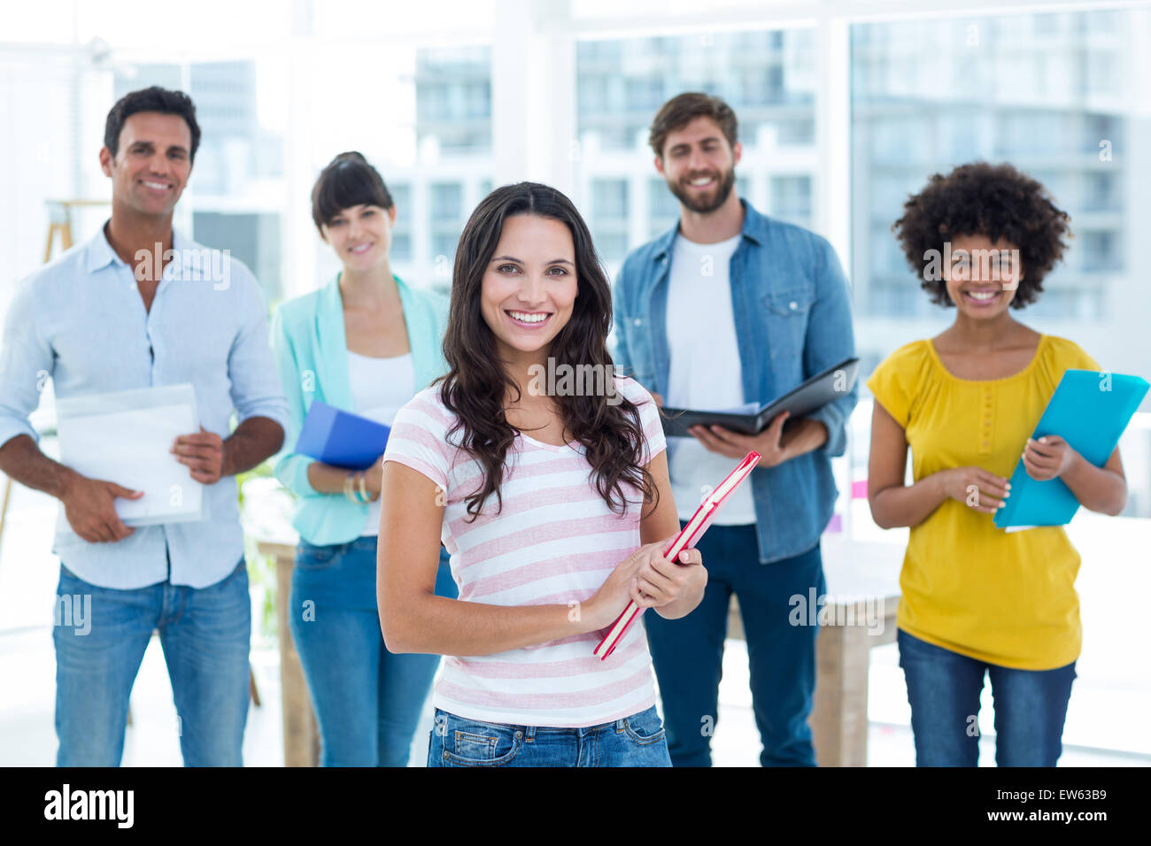 Portrait of creative business people holding files Stock Photo - Alamy