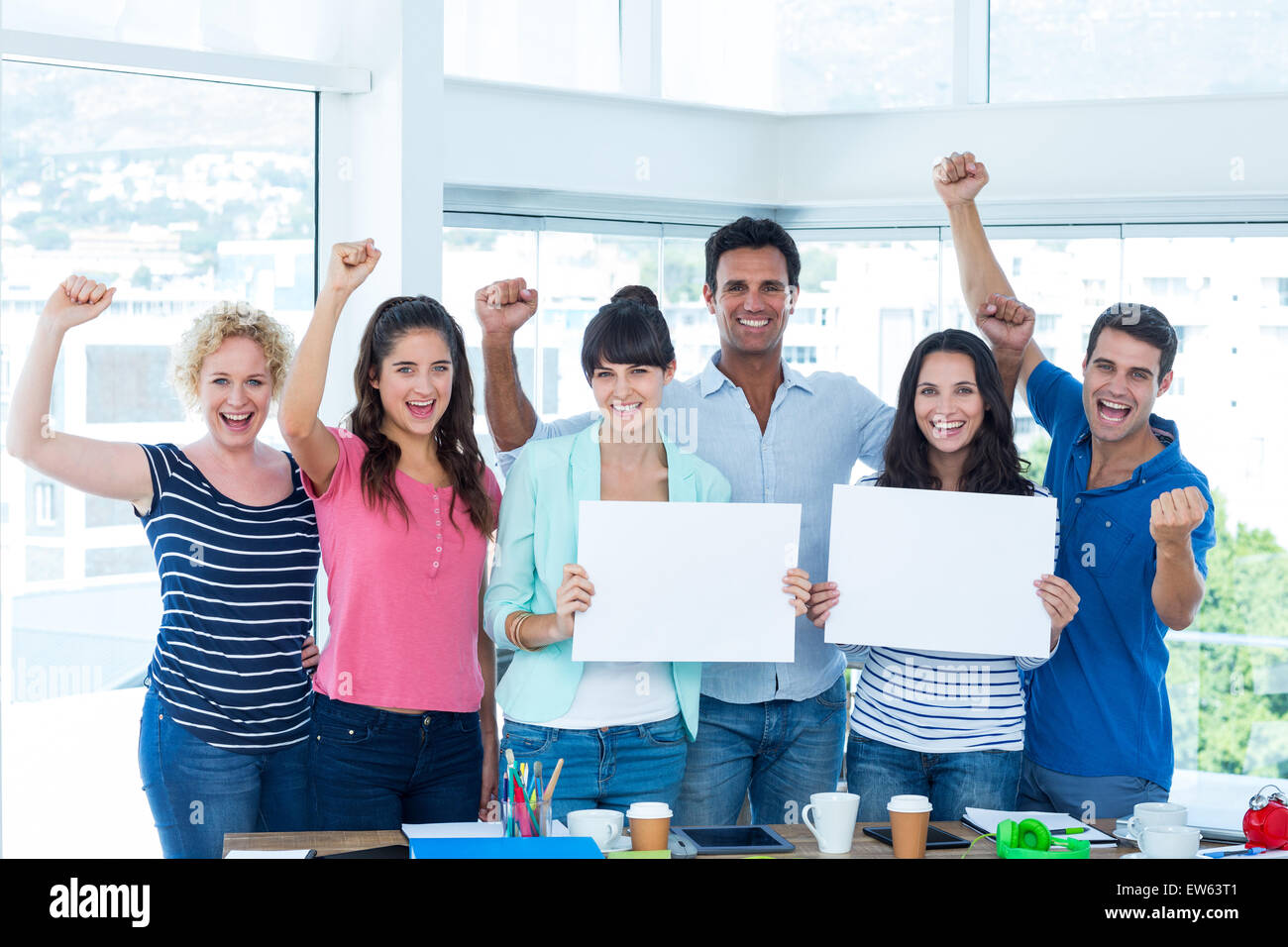 Happy business team holding a signboard Stock Photo - Alamy