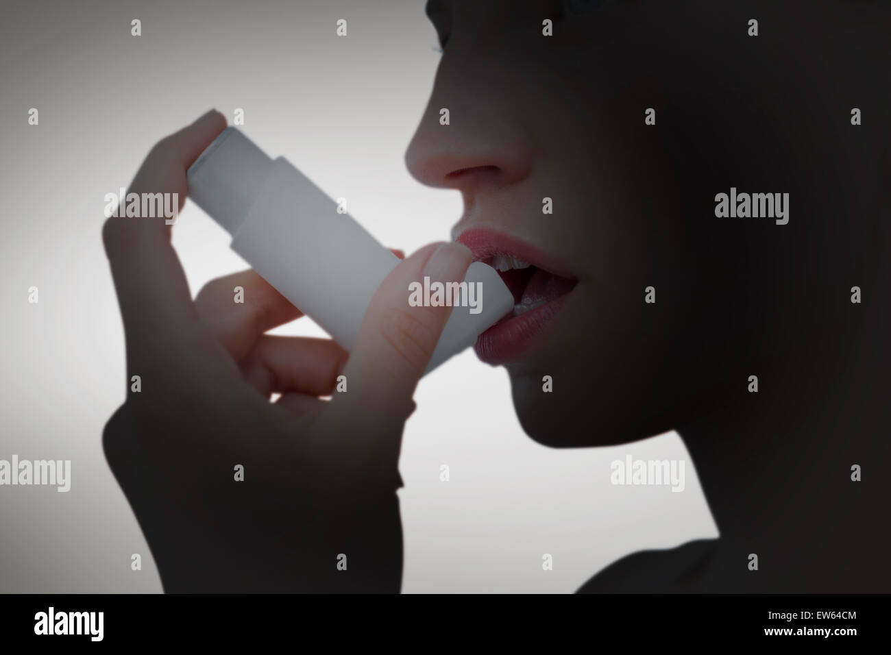 Composite image of blonde woman taking her inhaler Stock Photo - Alamy