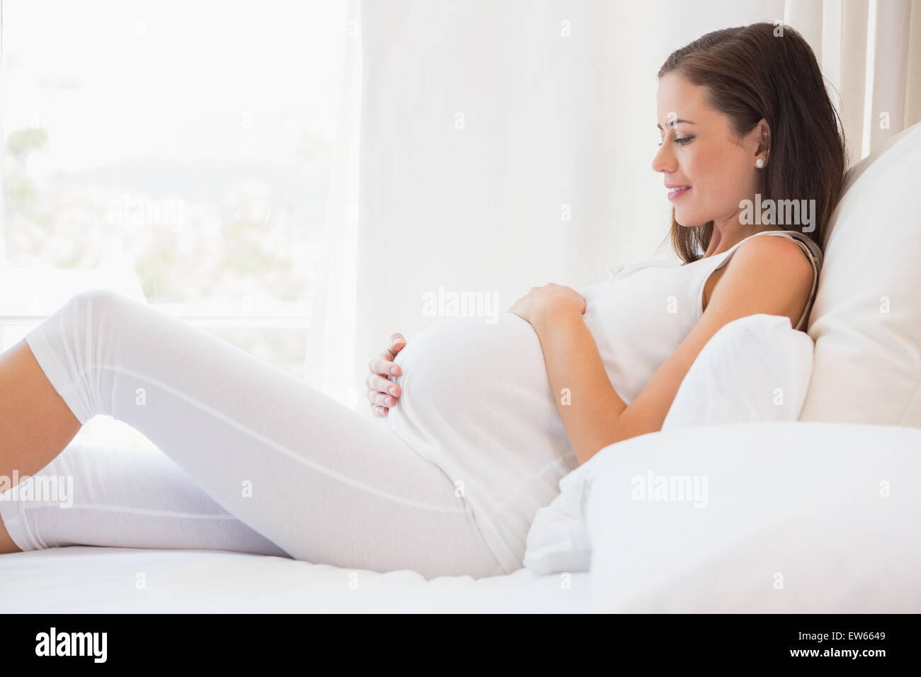 Happy pregnancy sitting on sofa Stock Photo - Alamy