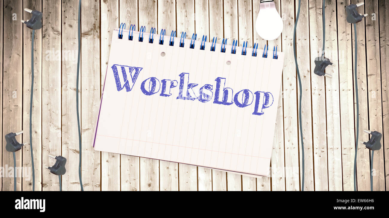 Workshop against notepad on wooden surface Stock Photo - Alamy