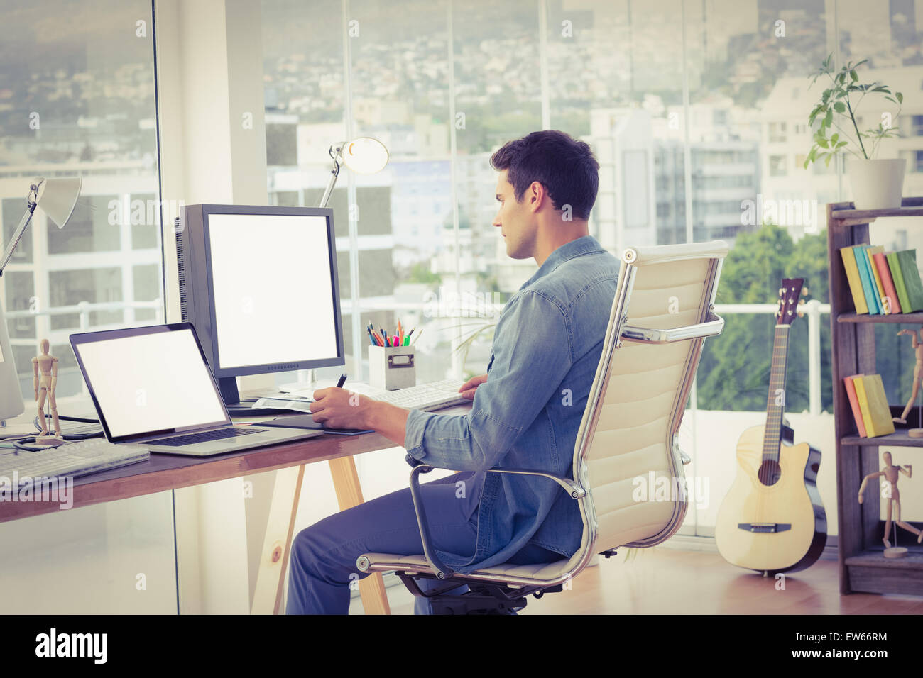 Casual businessman using computer in office Stock Photo - Alamy