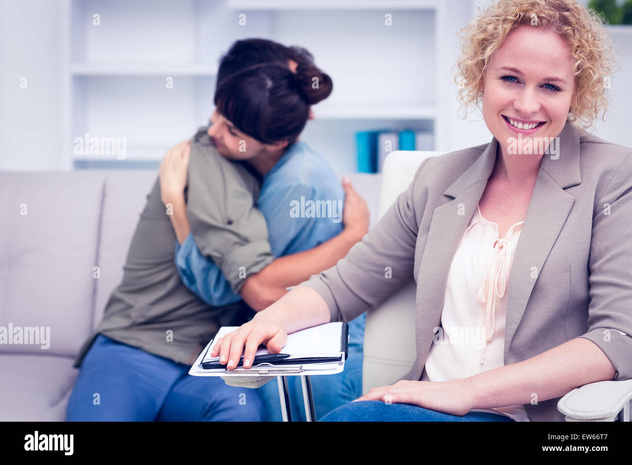 Smiling therapist with comforting patients in the background Stock ...
