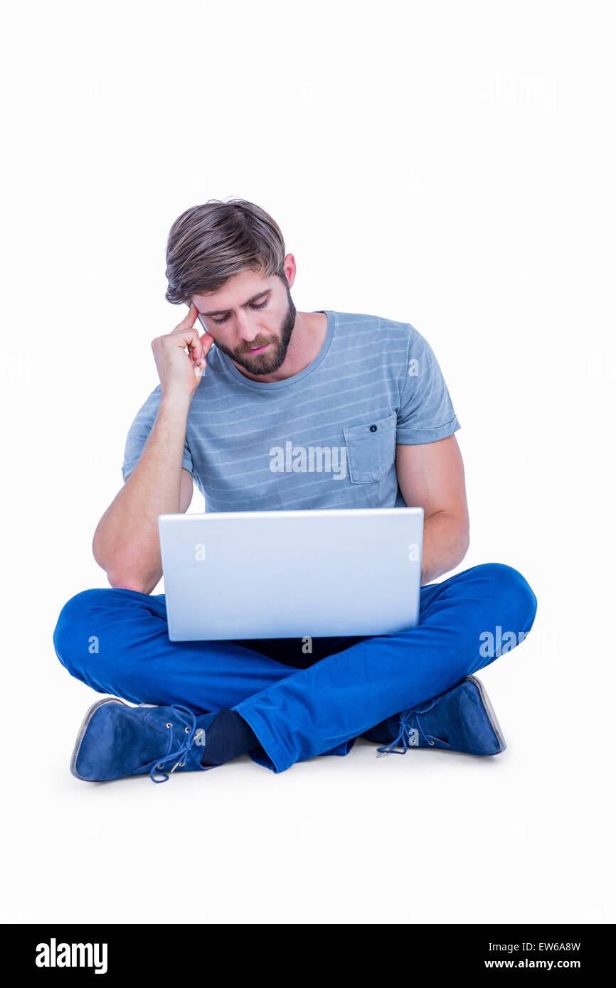 Handsome man thinking behind his laptop Stock Photo - Alamy
