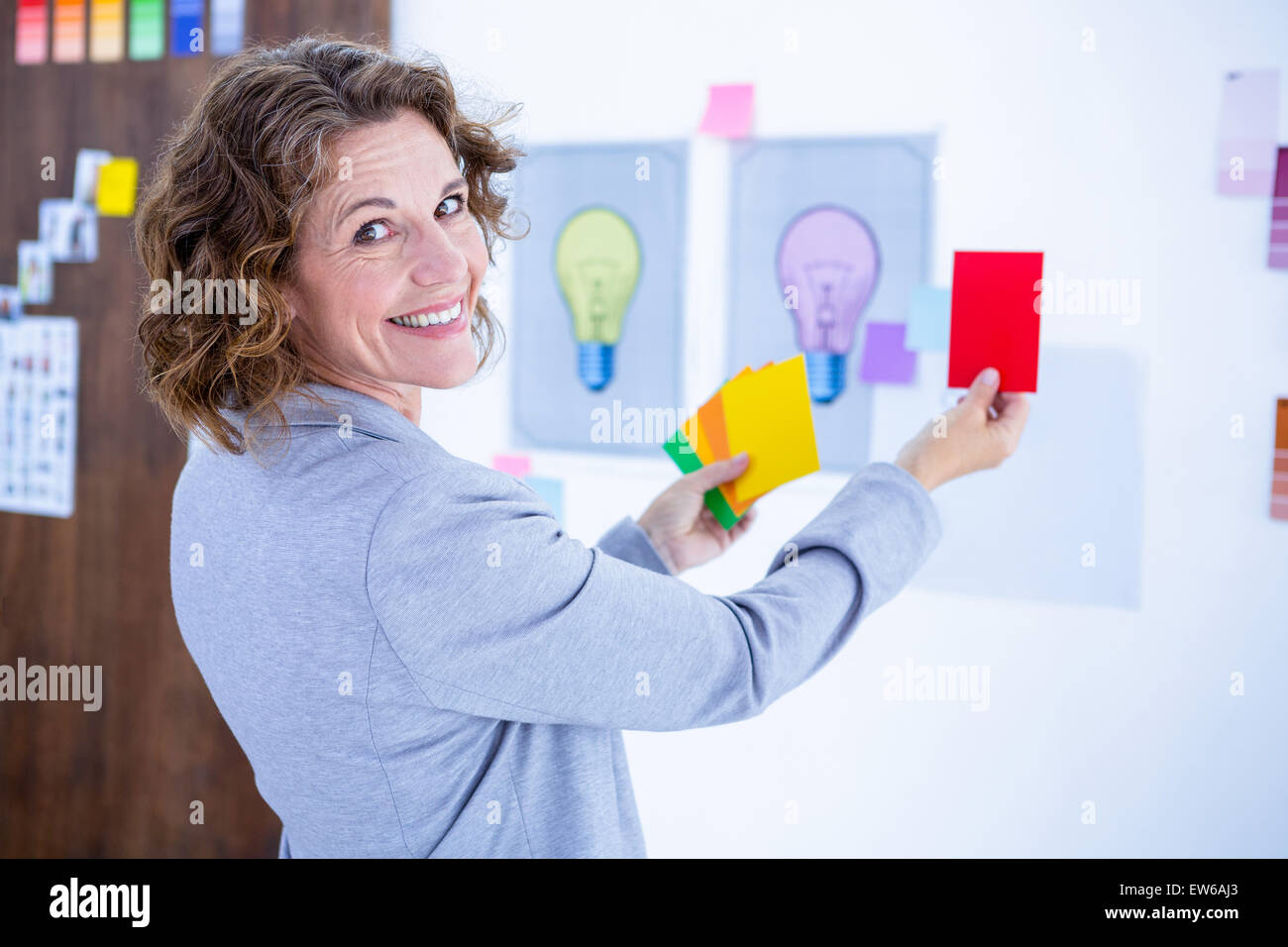 Creative businesswoman holding color cards and looking at camera Stock ...