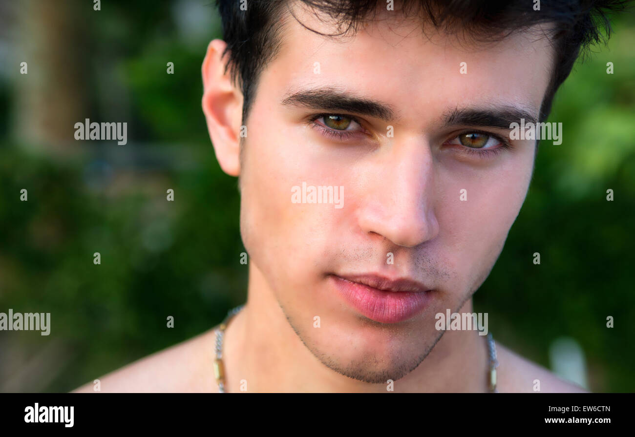 Headshot of handsome attractive young man looking at camera outdoor ...