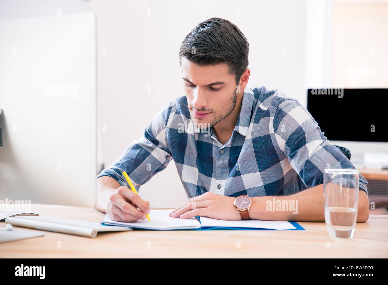 Businessman in casual cloth reading and signing document in office ...
