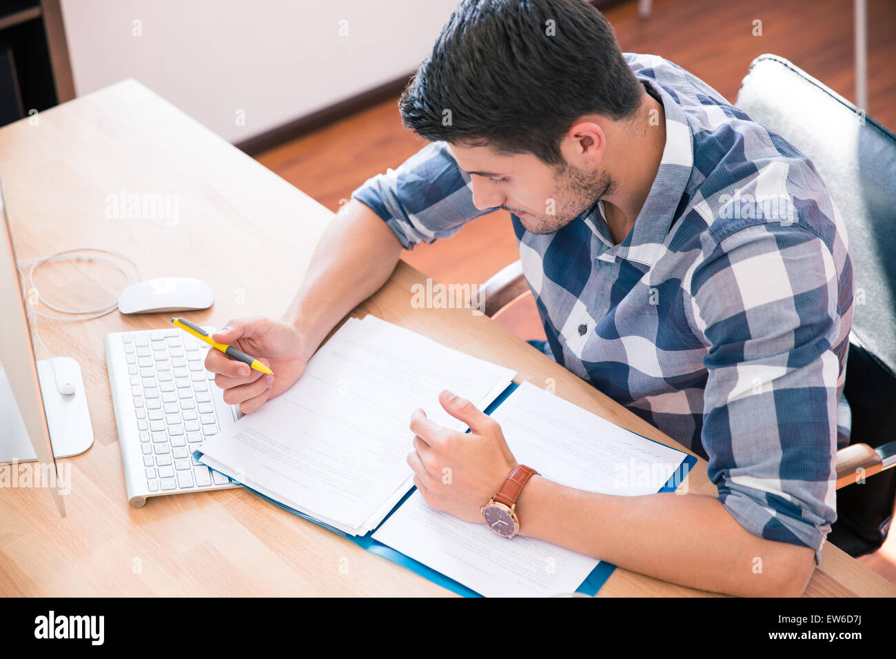 Businessman in casual cloth reading and signing document in office ...