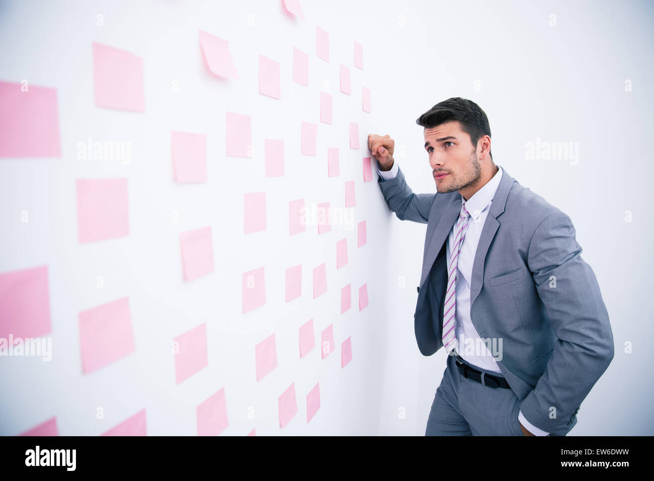 Handsome businessman looking on wall with stickers in office Stock ...