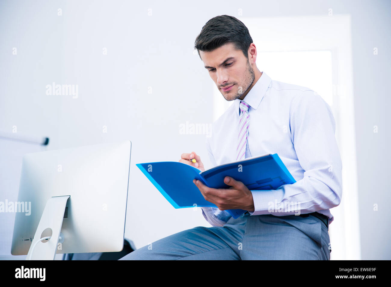 Businessman sitting on the table and reading document in office Stock ...
