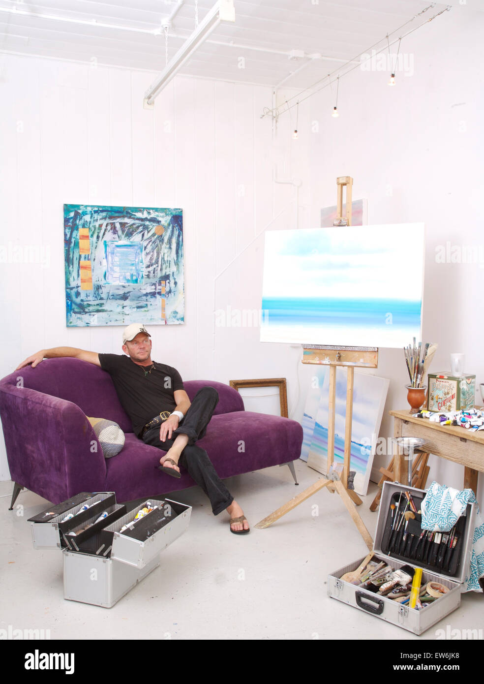 Portrait of an artist sitting on a purple sofa in his studio Stock ...