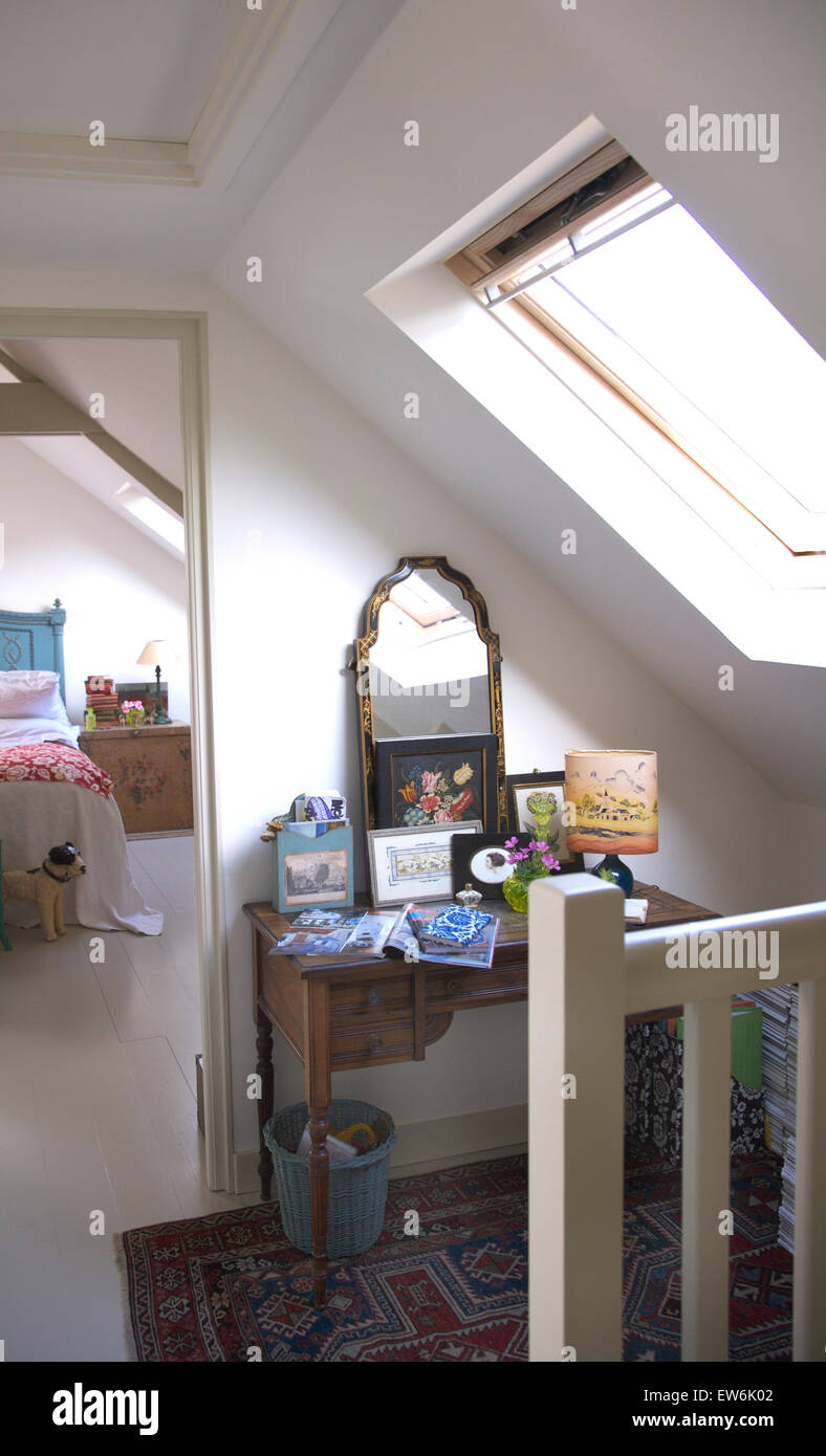Velux window above vintage mirror and small antique table on cottage ...