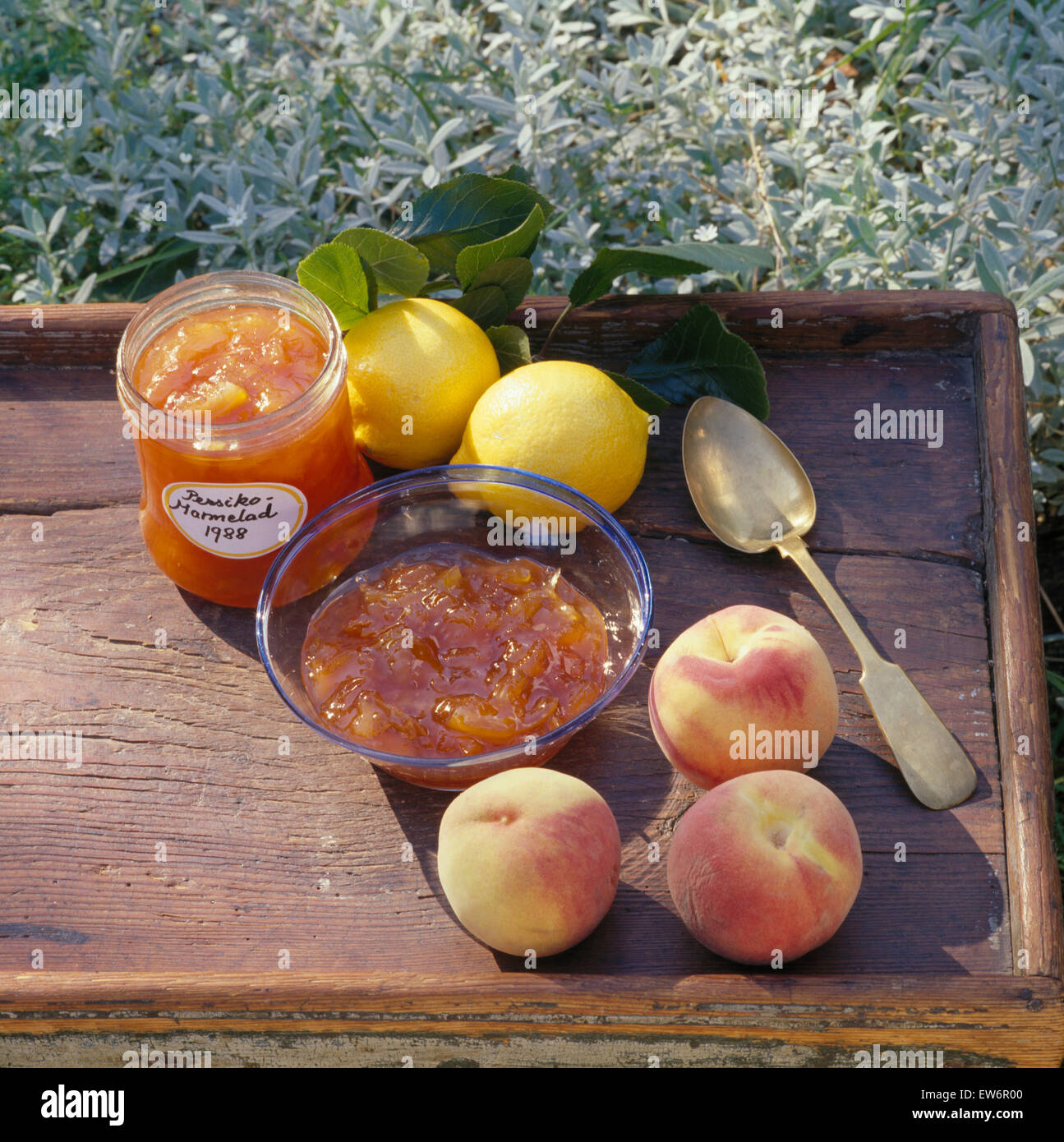Fresh peaches and lemons on a tray with a dish and a jar of home made ...