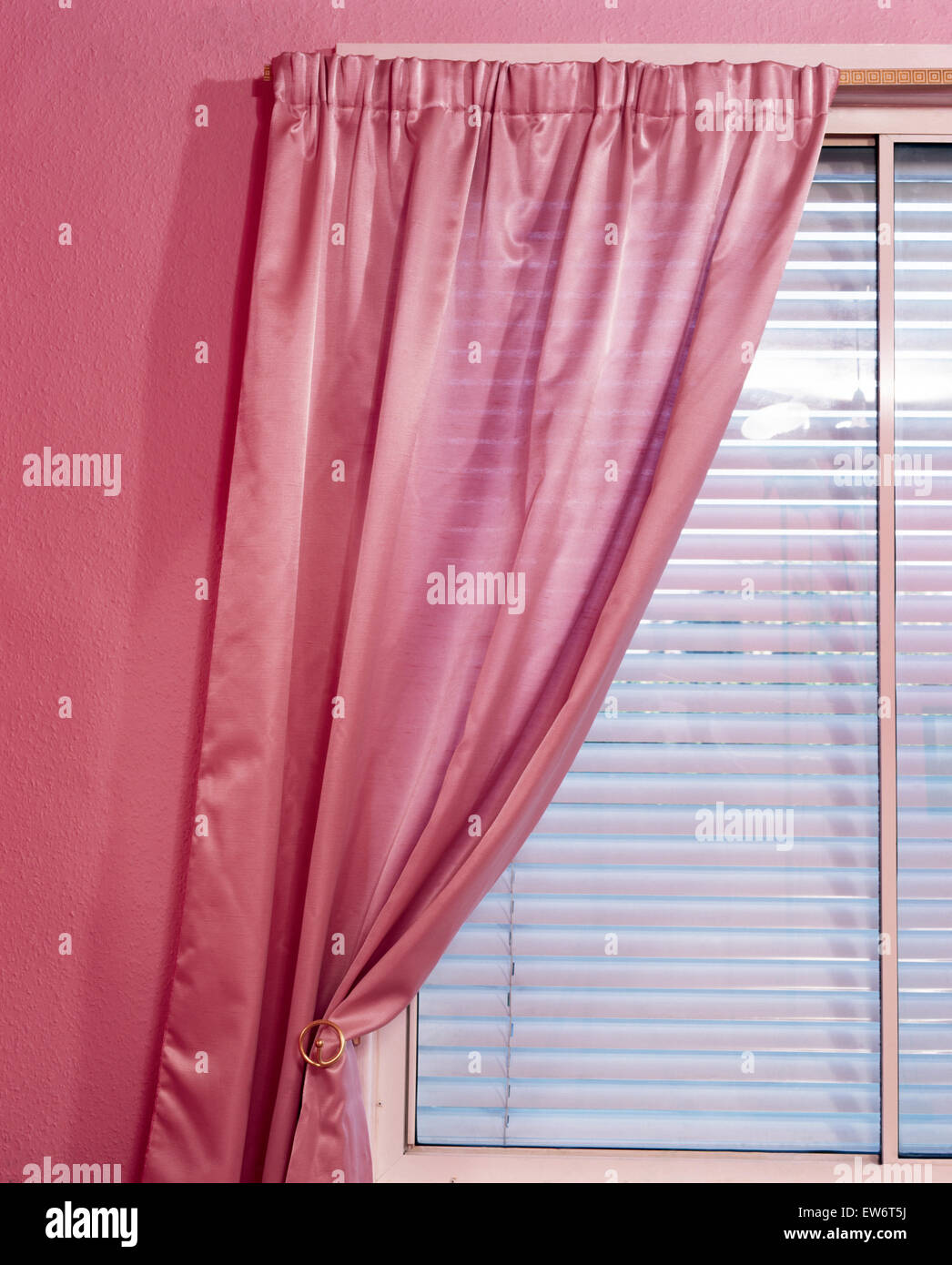 Close-up of a pink silk curtain and white slatted blind on window Stock ...