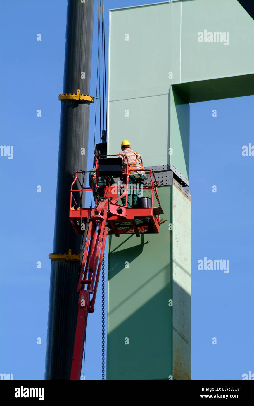 Two Worker installing a metal bridgehead in a harbor Stock Photo - Alamy