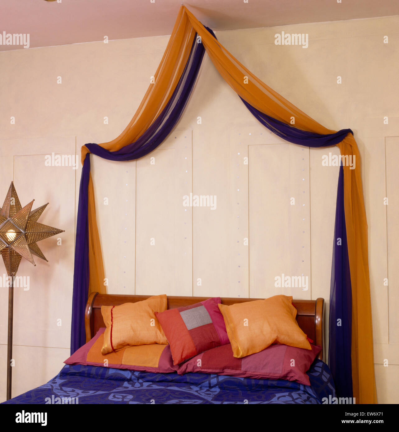 Drapes above bed in nineties economy style bedroom Stock Photo - Alamy