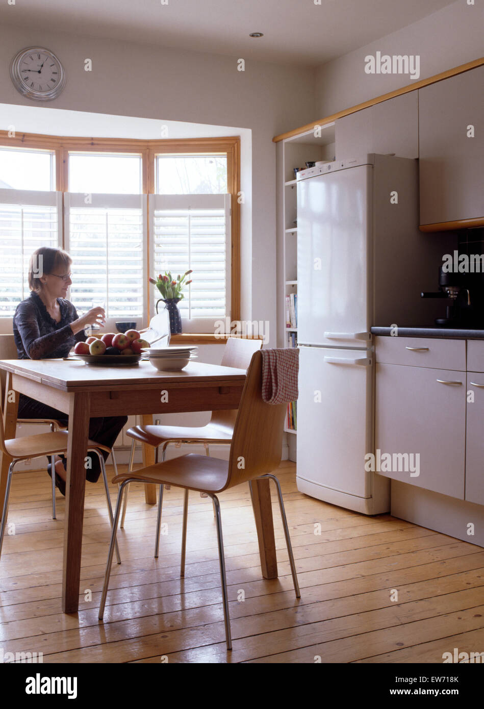 Woman reading at table in modern kitchen FOR EDITORIAL USE ONLY Stock ...