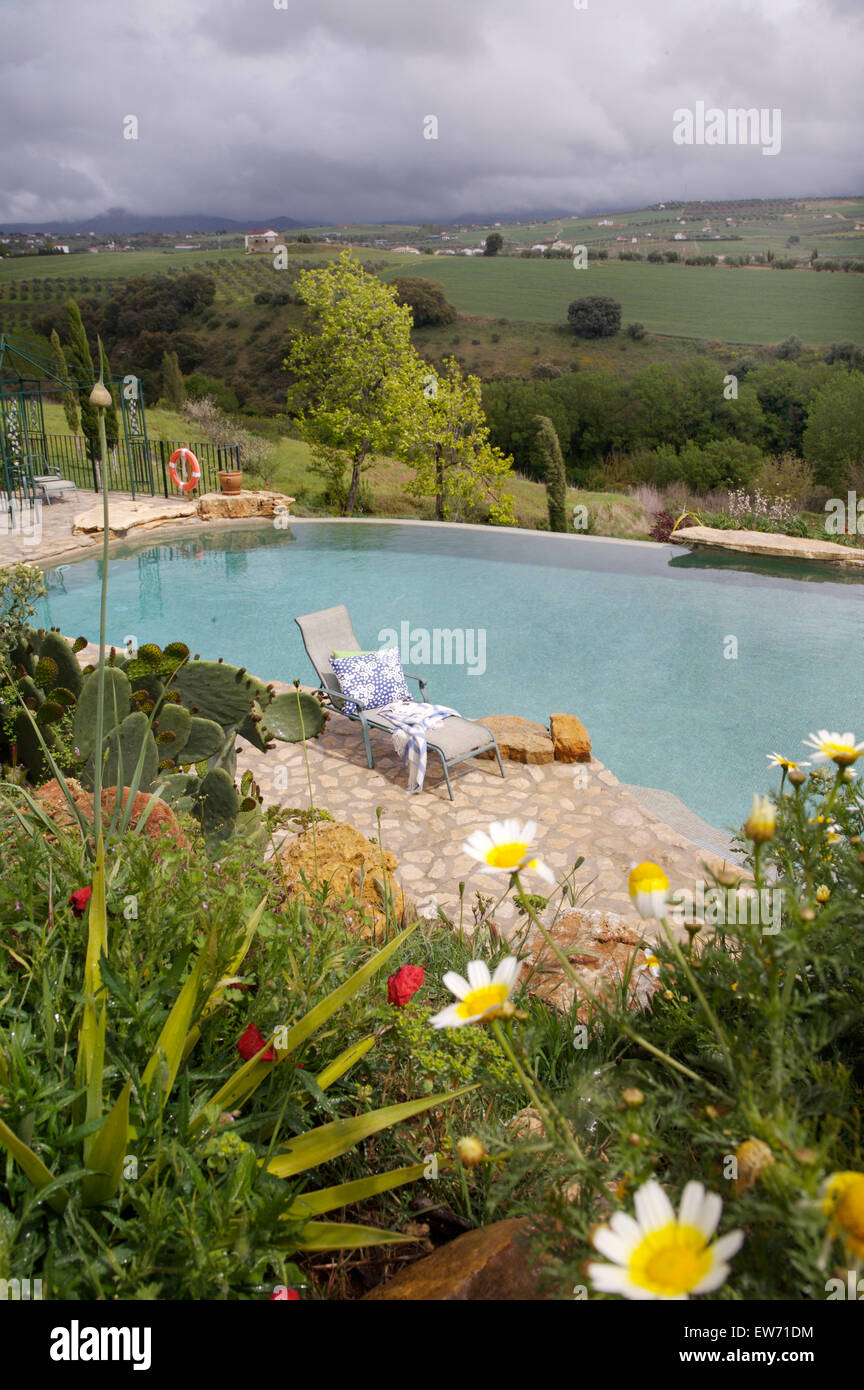 Lounger on paved area beside swimming pool in the Spanish countryside ...