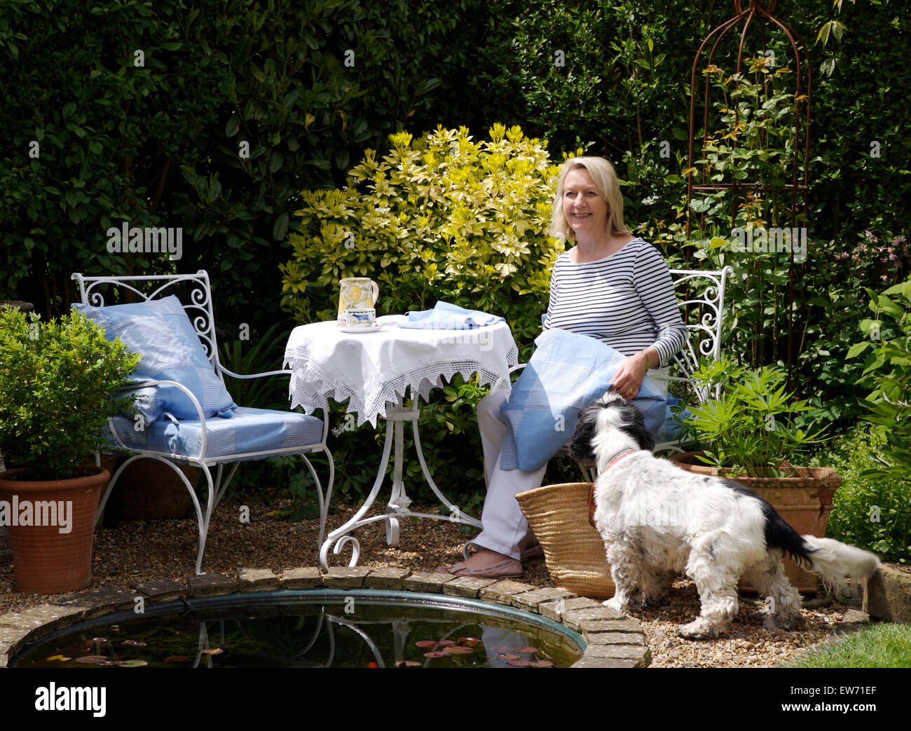 Portrait of a woman sitting at garden table on patio Stock Photo - Alamy