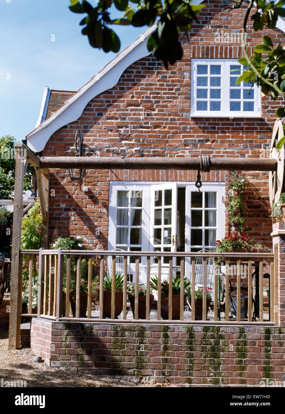 Exterior of brick country cottage with wooden fence on low wall Stock ...