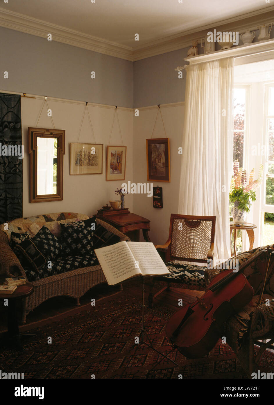 Cello and music stand in eighties living room with white voile curtains ...