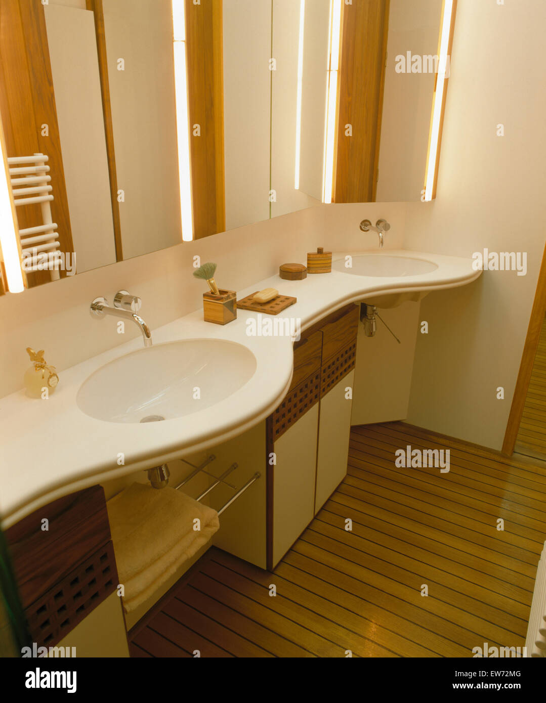 Lighted mirrors above basins in curved vanity shelf in thirties style ...