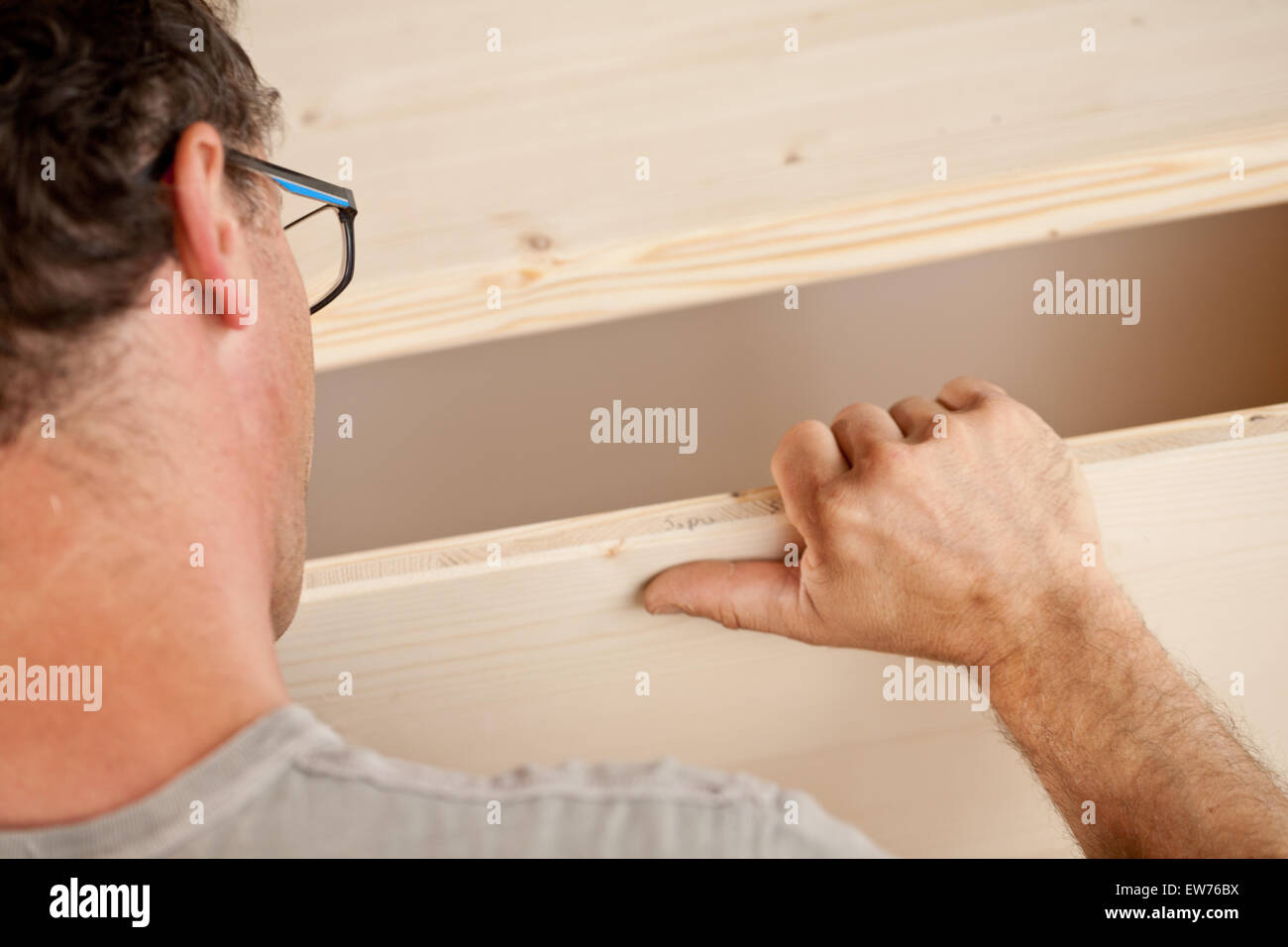 powerful arm and hand of a carpenter placing a component in a piece of ...