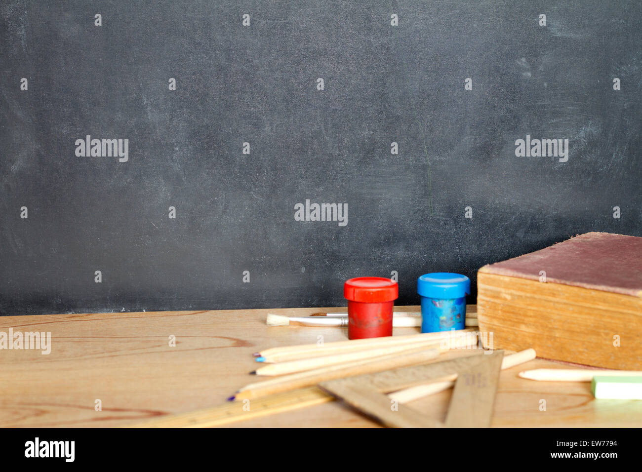 Old school supplies on blackboard background Stock Photo - Alamy