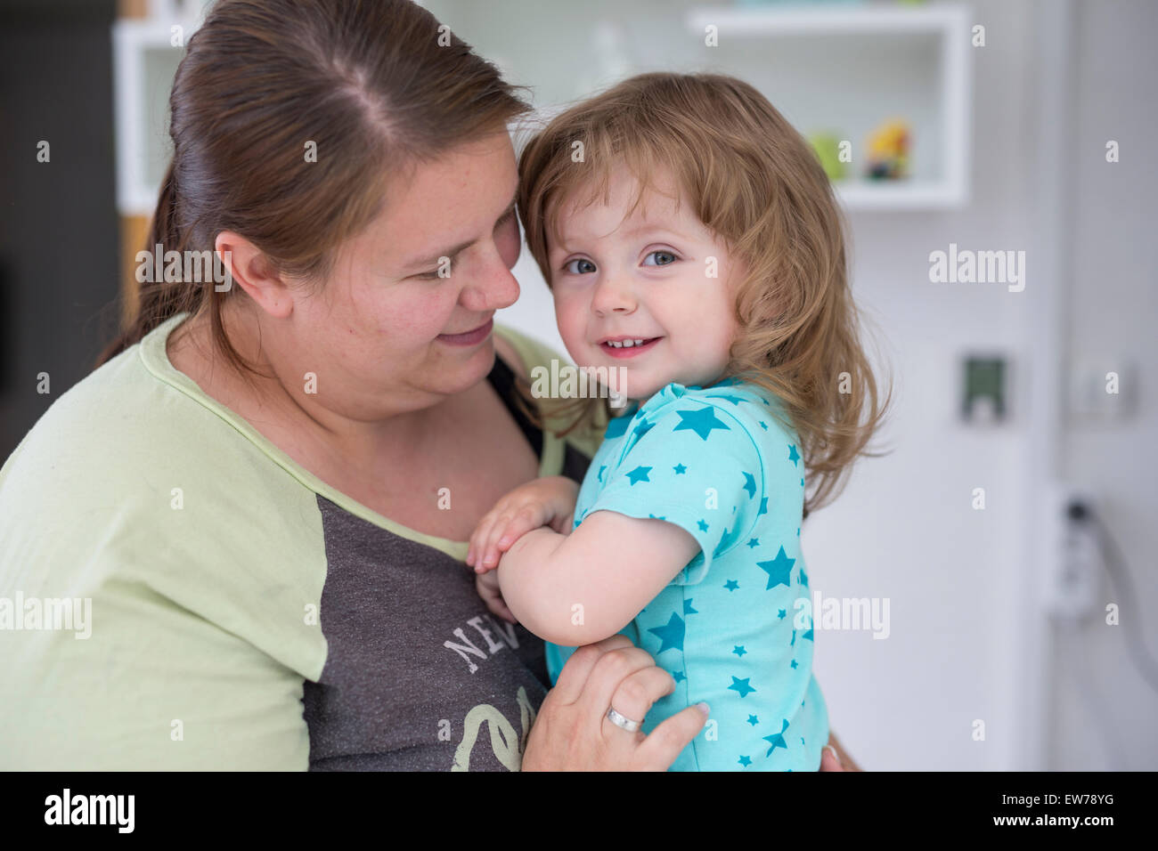 Little girl in mother's arms Stock Photo - Alamy