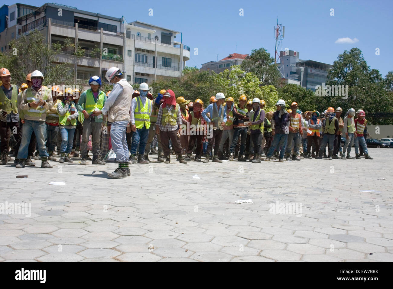 Construction workers take part in stretching exercises to enhance ...